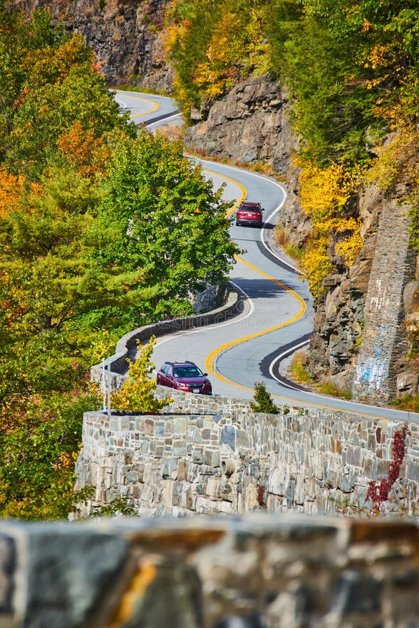 Winding Road with Cars and Stone Wall Going Up through Cliffs and ...