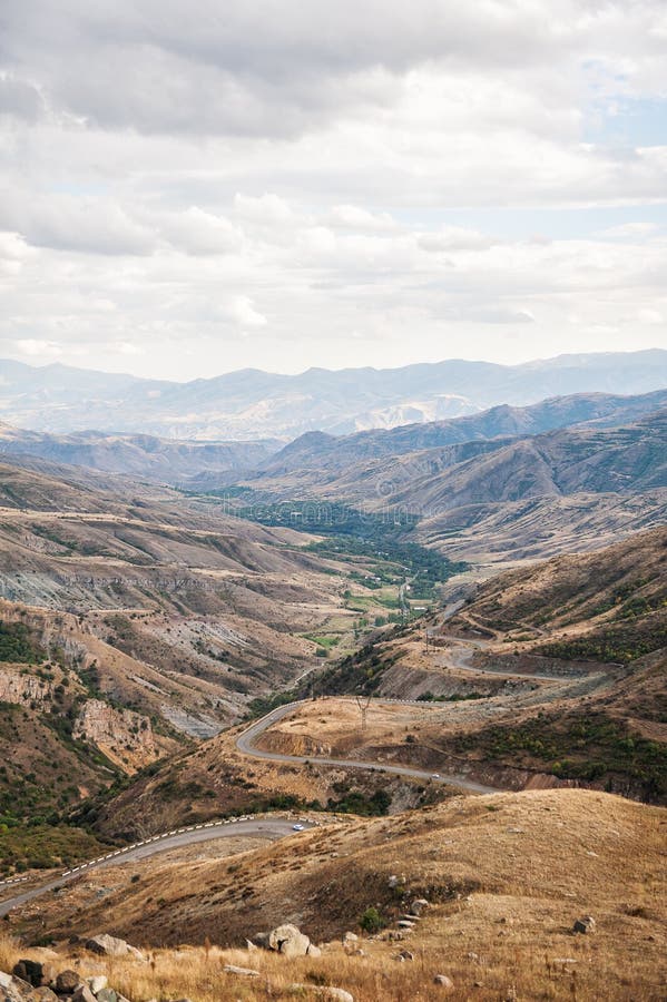 Winding Road Snakes through a Vast, Rugged Mountain Valley Stock Photo ... Winding Road Snakes through a Vast, Rugged Mountain Valley Stock Photo ...