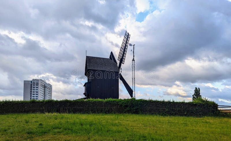 Windmill and High-rise House at the Cloudy Sky and Green Meadow Stock ...