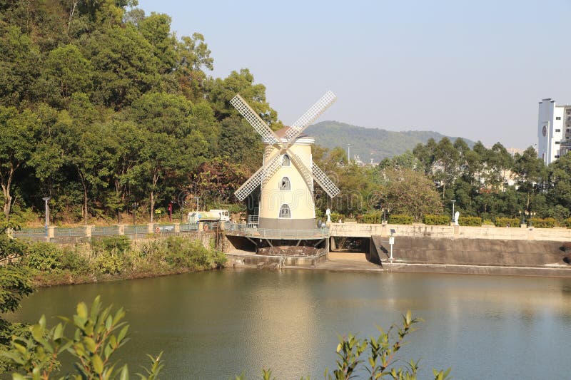 A Windmill is in the Middle of a Lake Stock Image - Image of peaceful ...