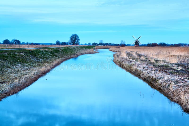 Windmill and river in dusk stock image. Image of farmland - 30634589