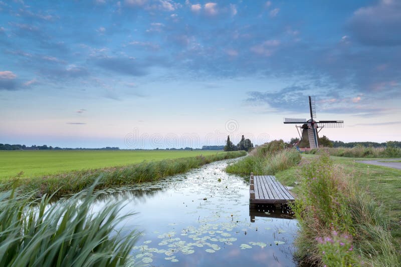 Windmill by River at Sunset Stock Image - Image of blue, people: 43863545
