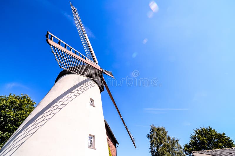 A Windmill is Standing Tall in a Field on a Sunny Day Stock Photo ...