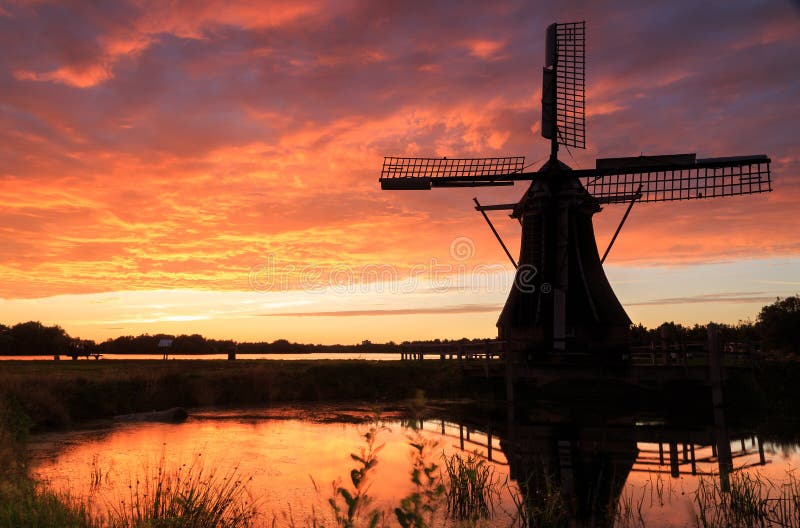 Windmill sunset at a lake stock photo. Image of meteorology - 238779682