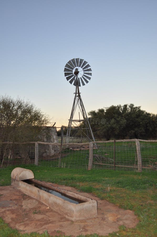 Windmill and Water Trough at Dusk Stock Photo - Image of australia ...