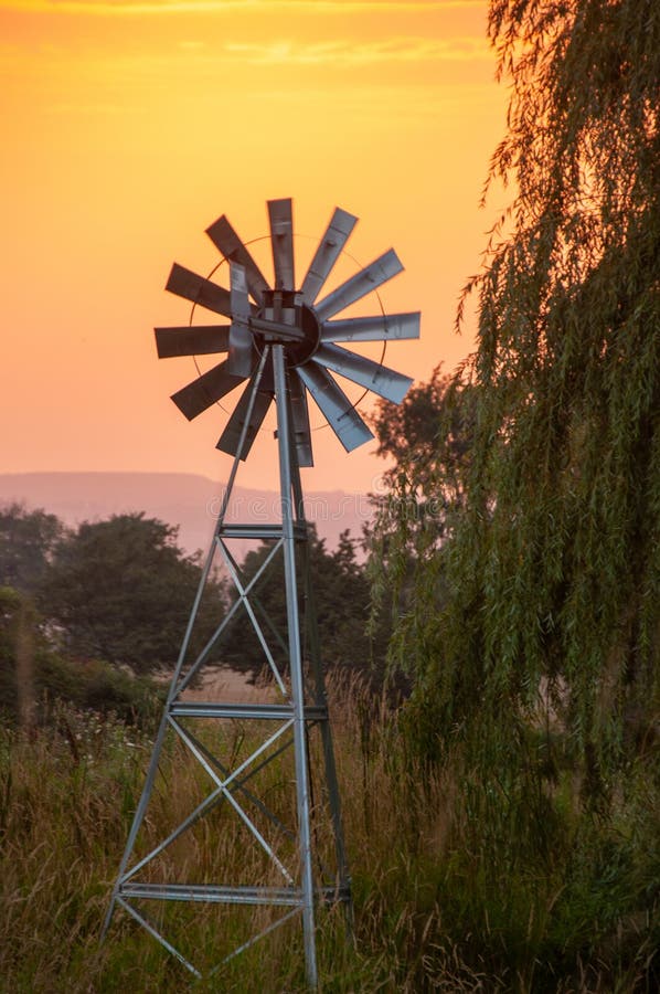 A Windmill beside a Willow Tree during a Stunning Sunset Stock Image - Image of beauty, sunset ...