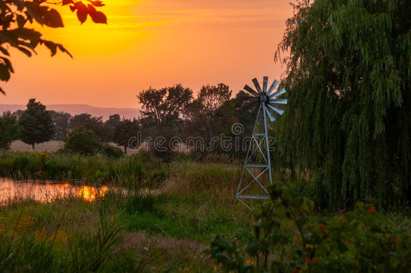 A Windmill beside a Willow Tree during a Stunning Sunset Stock Image - Image of orange, dramatic ...