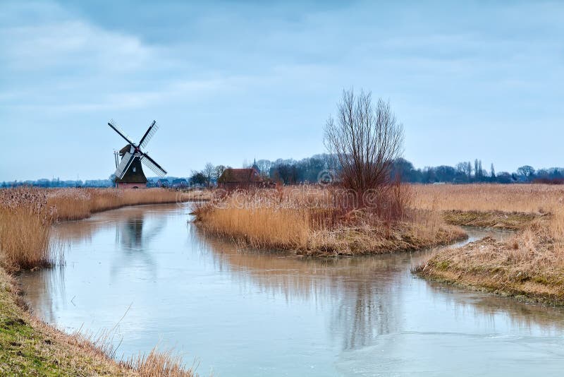 Windmill in Winter by Frozen River Stock Photo - Image of frozen ...