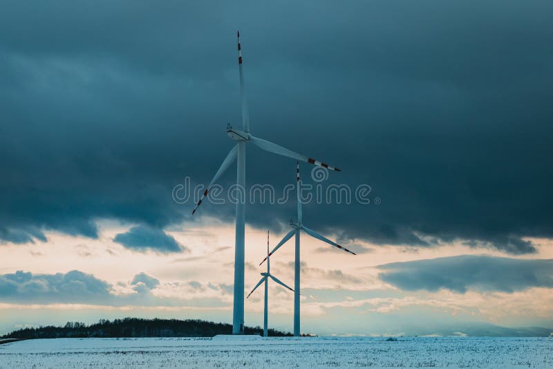 Windmills in a Snowy Field with a Cloudy Sky in the Background Stock ...