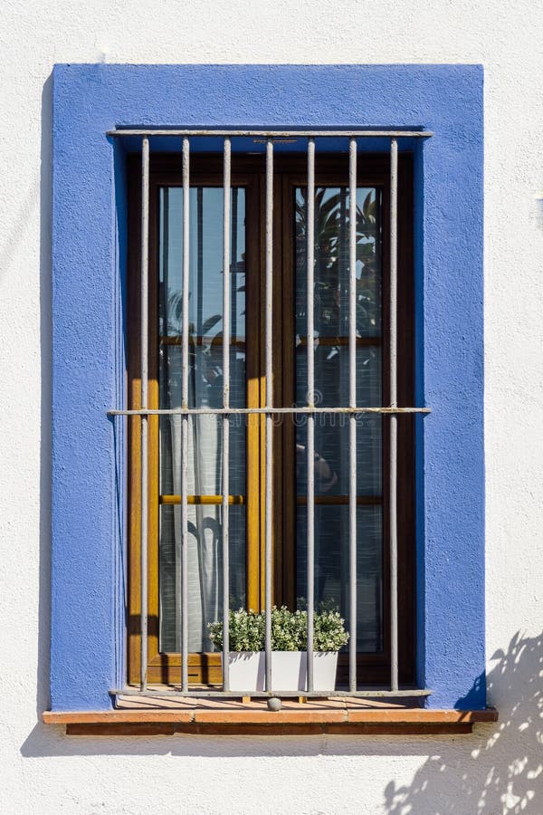 Window with Bars and Flowers on a Blue Facade Stock Image - Image of ...