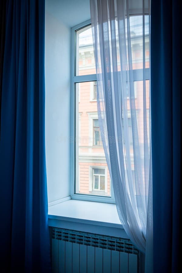 A Window with Blue Curtains and a Beautifully Falling Tulle. Stock ...