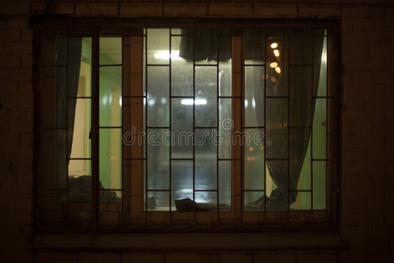 Window in Building in Evening. Grille on Window at Night Stock Photo ...