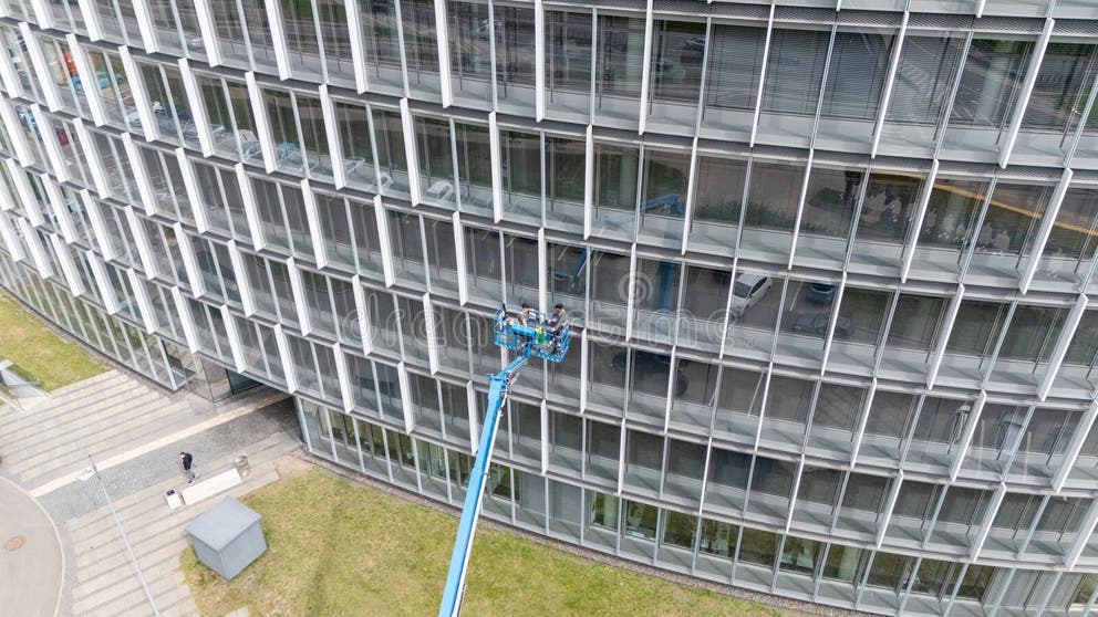 Window Cleaners on Cherry Picker at Modern Office Building Stock Photo ...