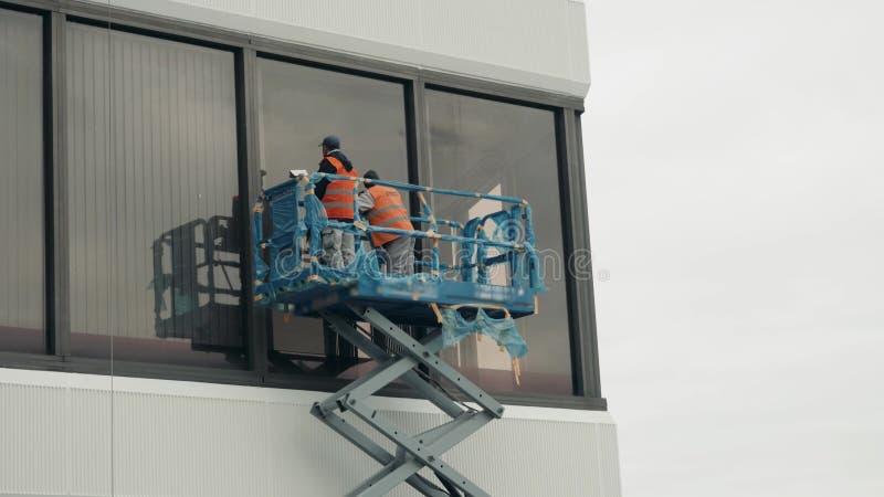 Working Man Glass Cleaner on a Hydraulic Lift Cleaning Window. Stock ...