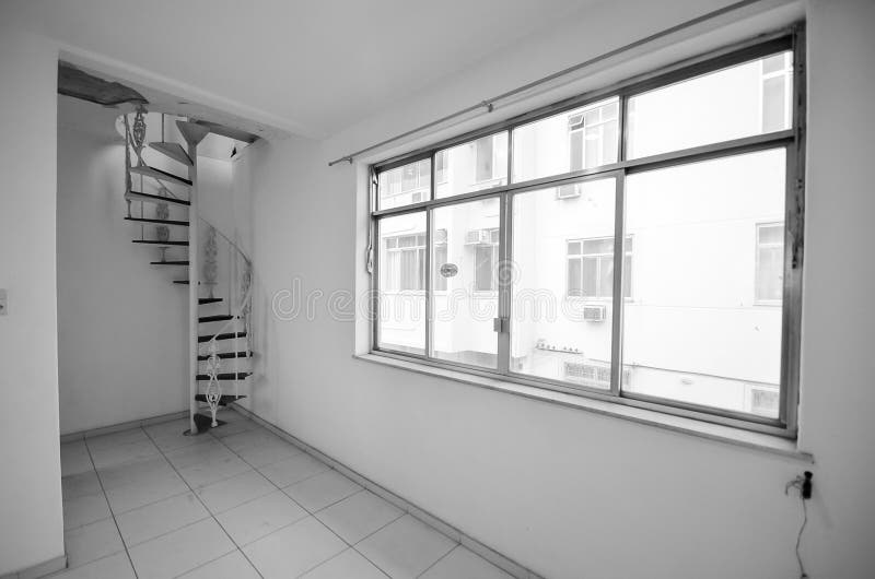 A Window in the Corner of a Small Room that Has a Stair Case and Some ...