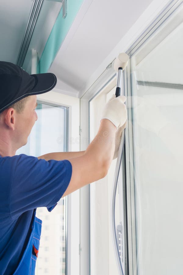 Window Installation Worker Inserts Glass into the Frame and Fastens the ...