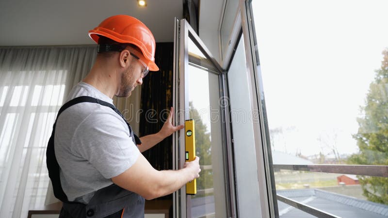 Window Installer Adjusting Plastic Windows with Level Tool in Room at ...