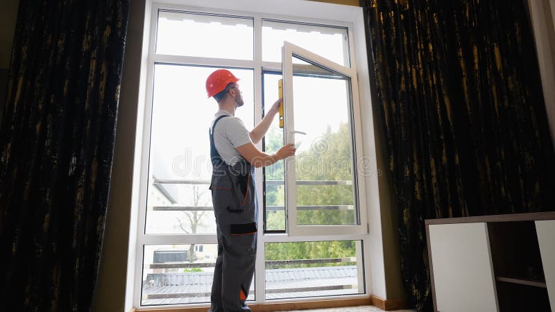 Window Installer Adjusting Plastic Windows with Level Tool in Room ...