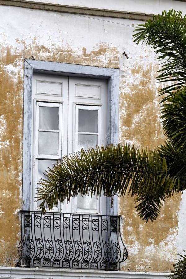 Window with Iron Balcony in an Old Worn Brown Plastered Wall with Palm ...