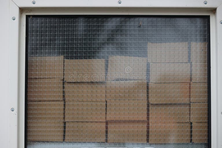 A Window with a Mesh Screen and a Stack of Boxes Behind it Stock Image ...