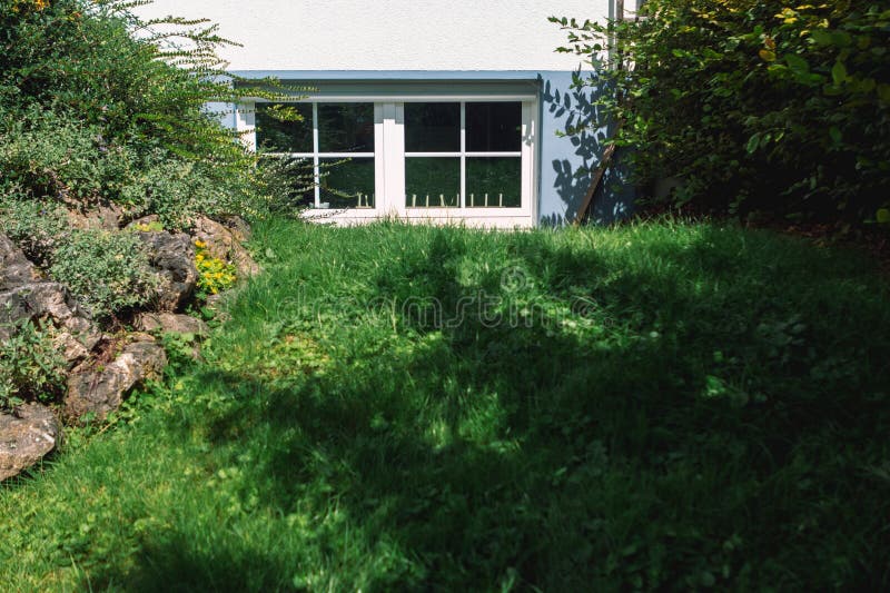A Window of a Semi-basement in a House on a Hill Overlooking a Green ...