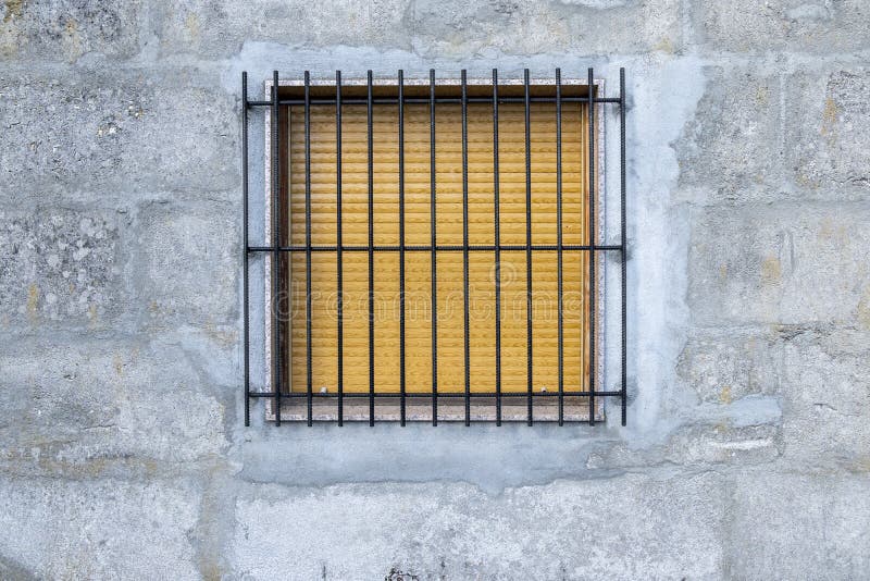Window with the Shutter Down and Iron Bars on a Concrete Wall, Security ...