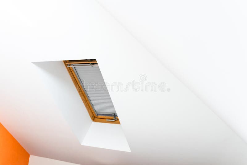 A Window on a Sloping Wall Under the Roof of a House with White Walls ...