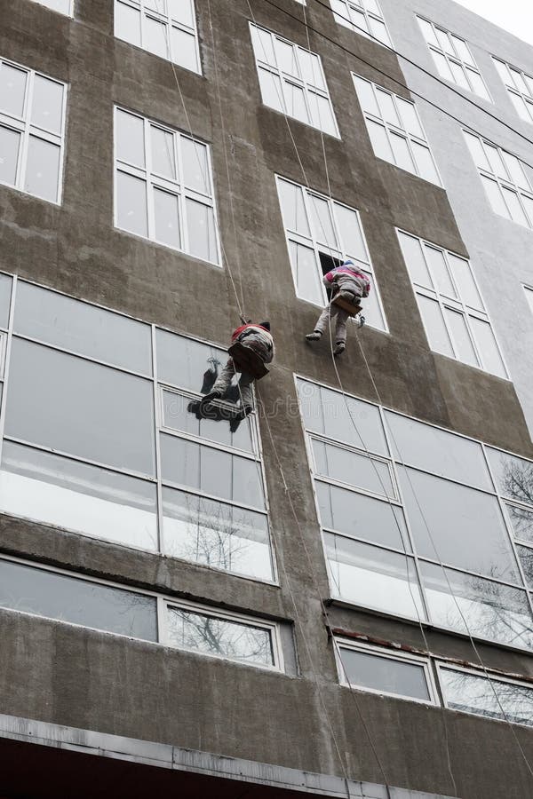 Window Washers on Top. Two Workers Hung Ropes Wash Windows on High-rise ...