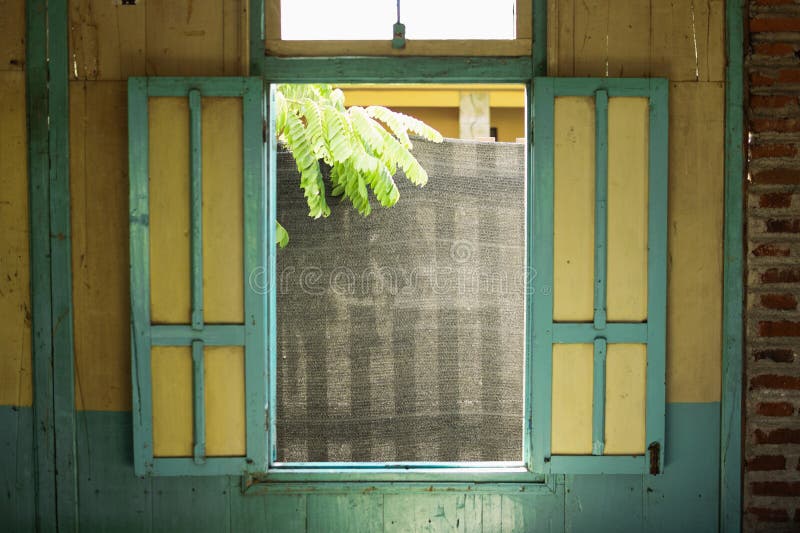 A Window with Wooden Shutters that are Half Open Revealing a View of ...