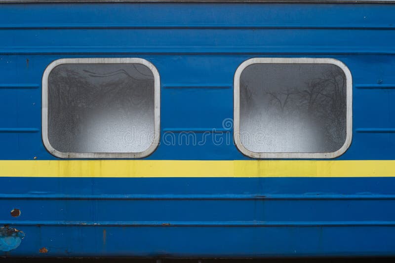 Windows of a Blue Passenger Car of a Train with a Yellow Stripe Below ...