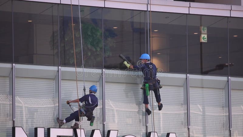 Windows Cleaner are Cleaning Building Windows. Using Ropes. Group of ...