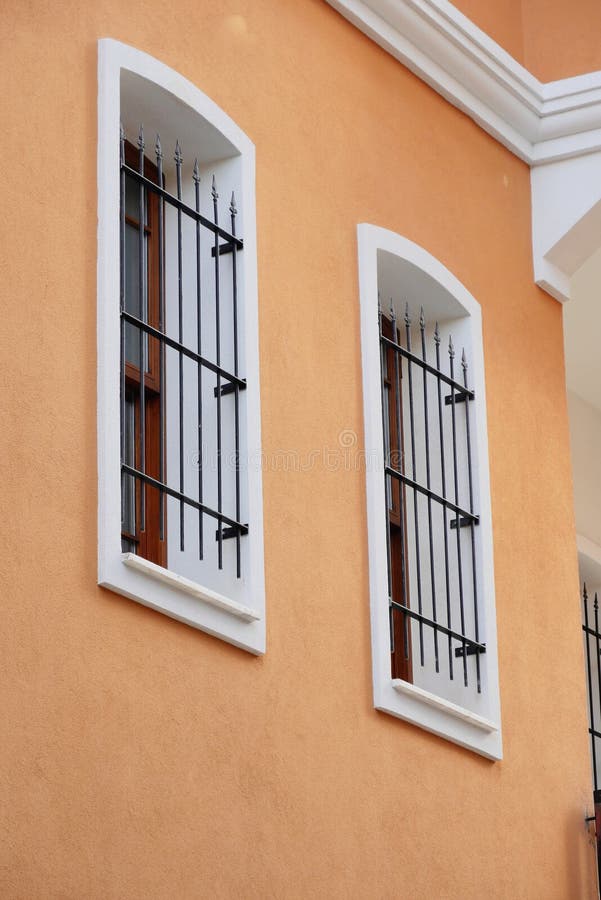 Windows with Decorative Iron Bars on an Orange Wall Exterior Stock ...