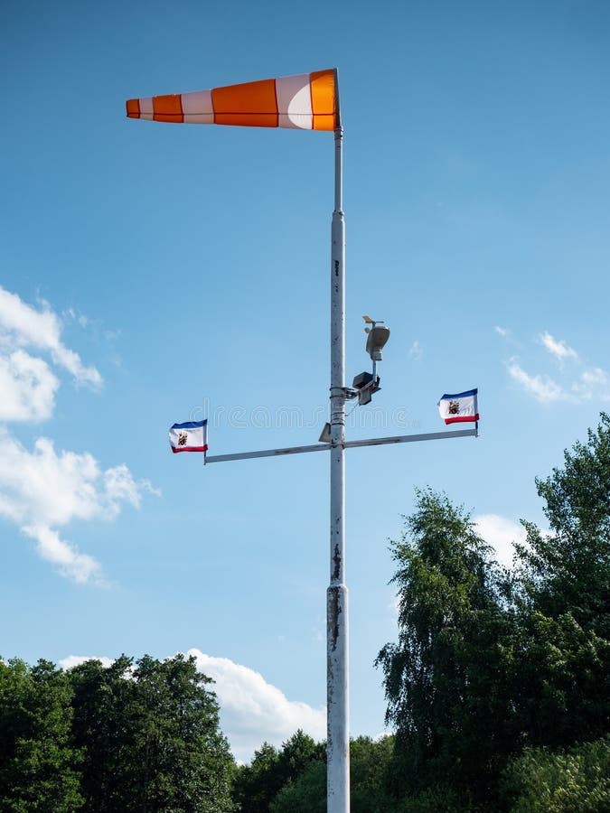 Windscock and Flag Flutter in the Wind on a Tall Pole. the Weather ...