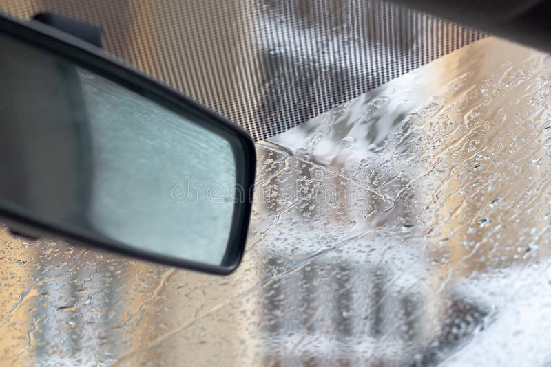 The Windshield of a White Car is Covered with Water Droplets during ...