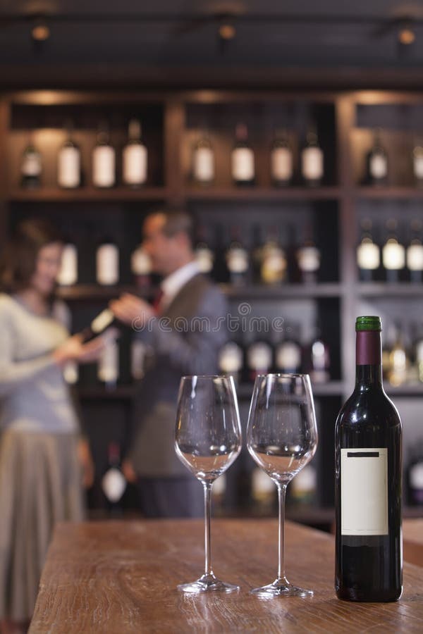 Wine Bottle with Two Glasses, People in the Background Stock Photo ...
