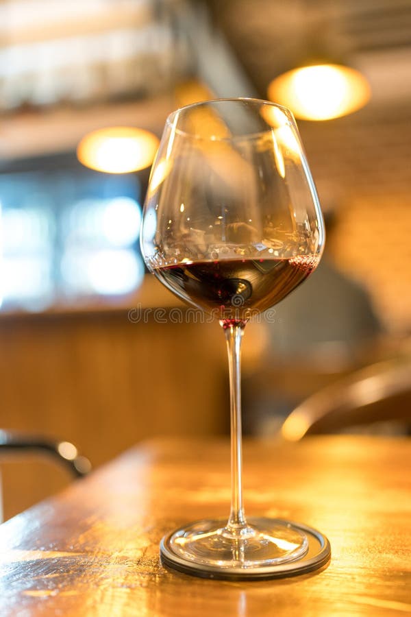 A Wine Glass is Filled with Red Wine on a Table Stock Image - Image of ...