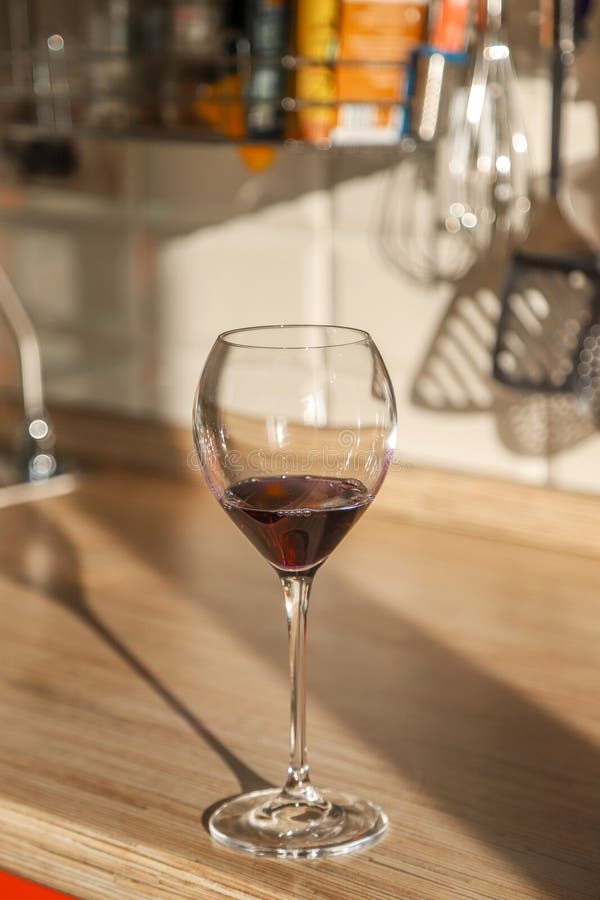 Wine Glass with Red Wine in it on the Kitchen Counter in a Sunny Day ...
