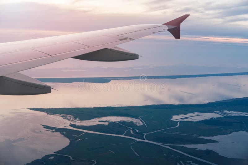 Wing Aircraft Flying Over the Bay and Part of the Land at Sunset Stock ...
