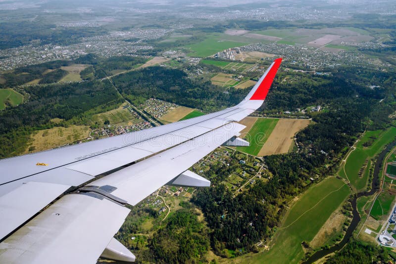 Wing of an Airplane Flying Above the Clouds and Ground, Russia Stock ...