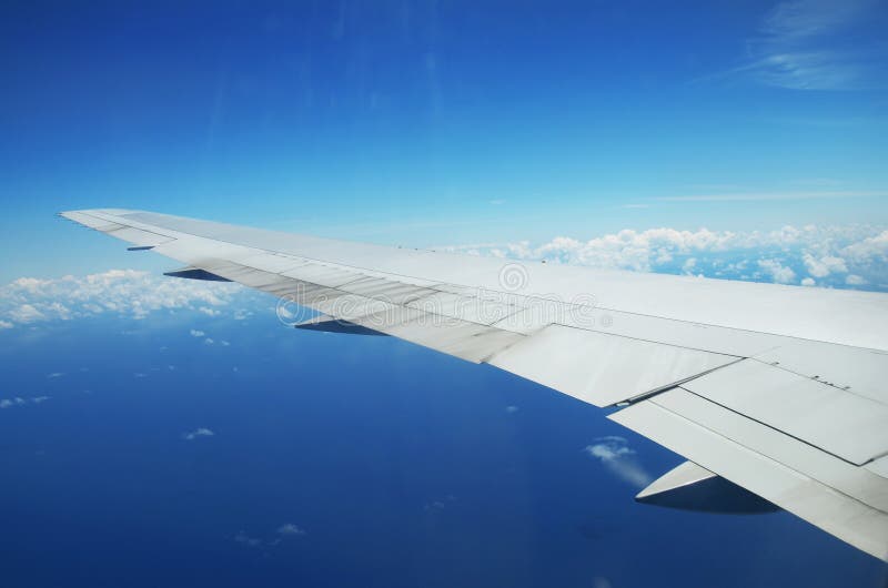 Wing of an Airplane Flying Above the Clouds Over Tropical Island Stock ...