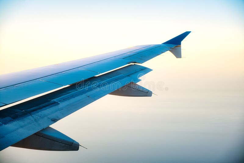 Wing of an Airplane Flying High Over the Clouds during the Daytime ...