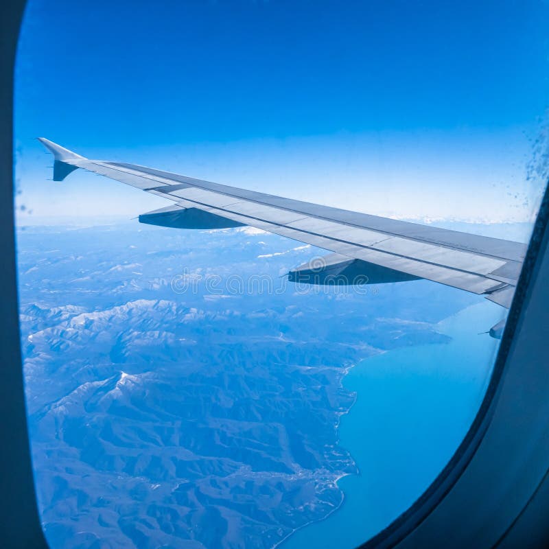 The Wing of an Airplane Flying Over the Mountains and the Sea Stock ...