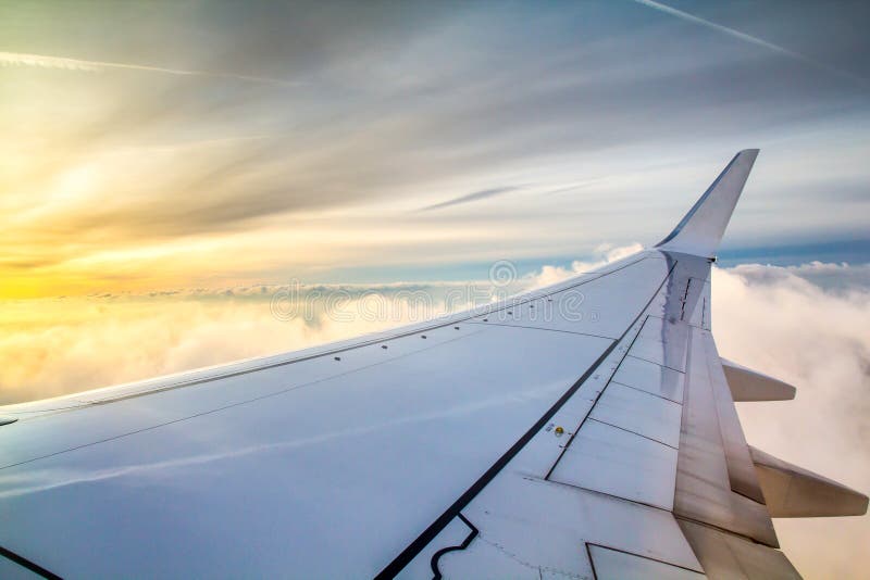 Wing of airplane in sunset stock photo. Image of plane - 126009408