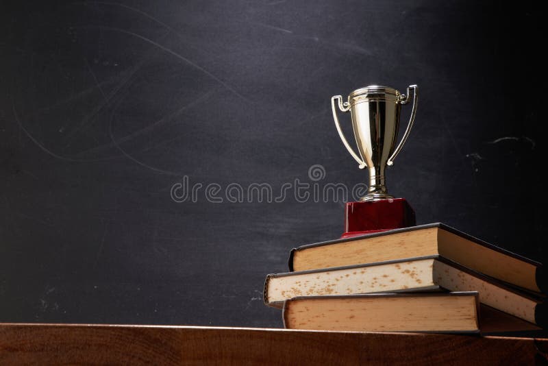 Wining Trophy on Stack of Book Against Blackboard Stock Photo - Image ...