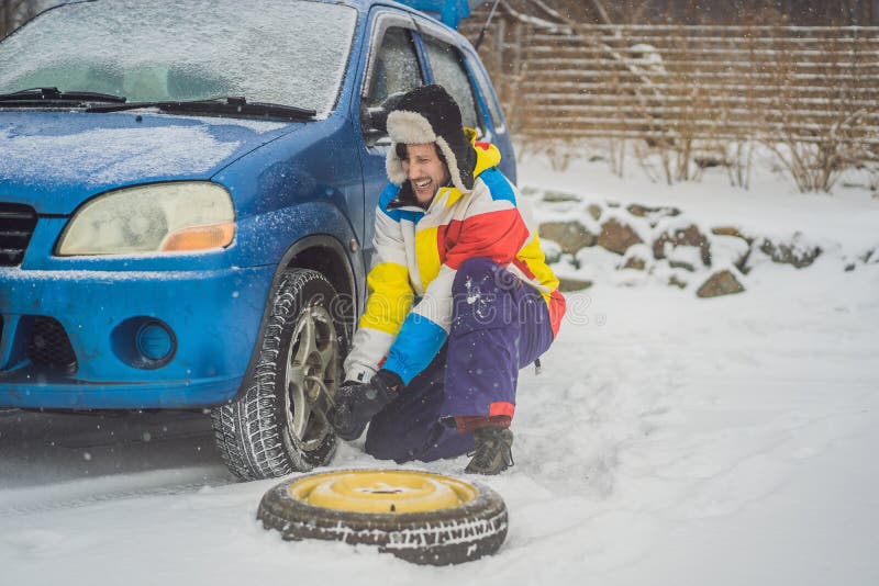 Winter Accident on the Road. a Man Changes a Wheel during a Snowfall ...