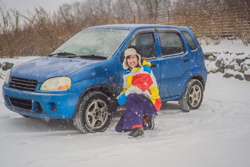 Winter Accident on the Road. a Man Changes a Wheel during a Snowfall ...