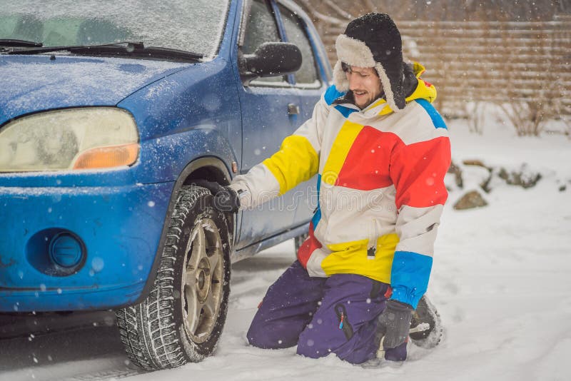 Winter Accident on the Road. a Man Changes a Wheel during a Snowfall ...