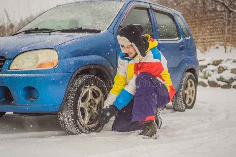 Winter Accident on the Road. a Man Changes a Wheel during a Snowfall ...