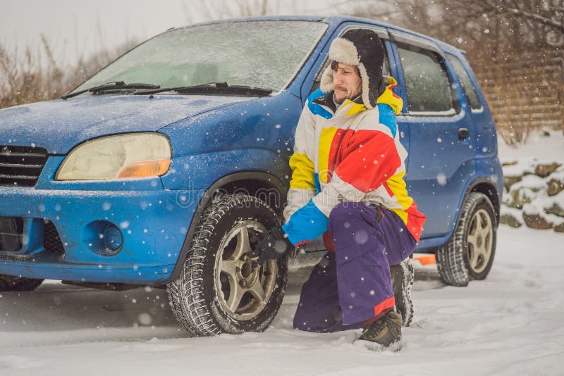 Winter Accident on the Road. a Man Changes a Wheel during a Snowfall ...