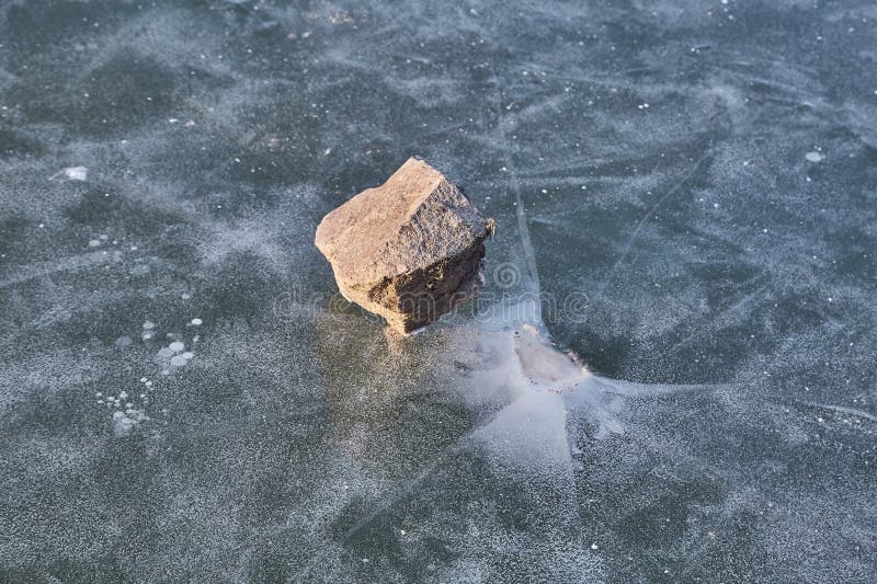 Winter Ice with Cracks Under Stone Throw Stock Photo - Image of danger ...